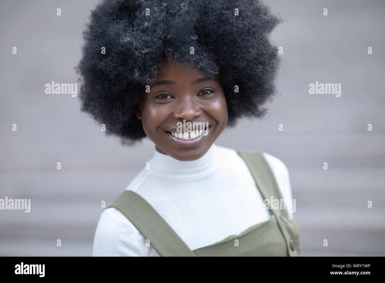 Gorgeous looking young black girl smiling broadly looking at the camera ...