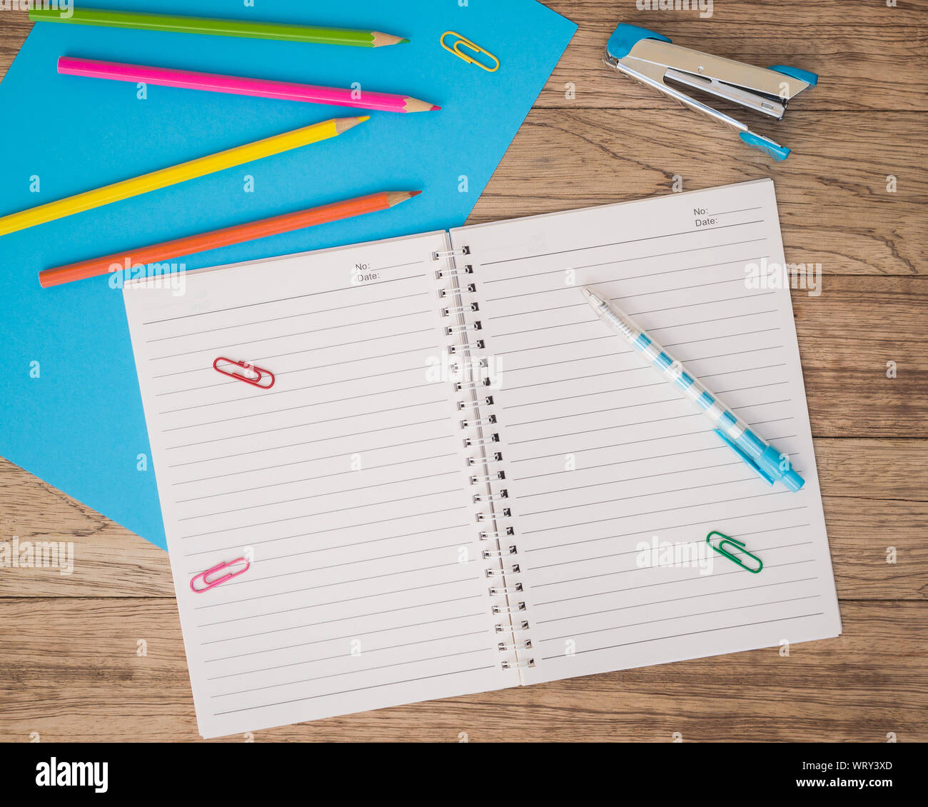 Notebook, paper, stapler, pen and other on wooden plank, Education ...