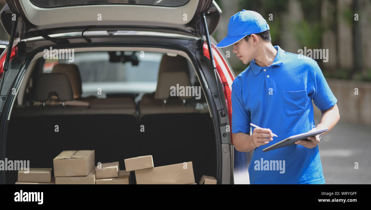 Delivery man checking orders on tablet, preparing the products to ...