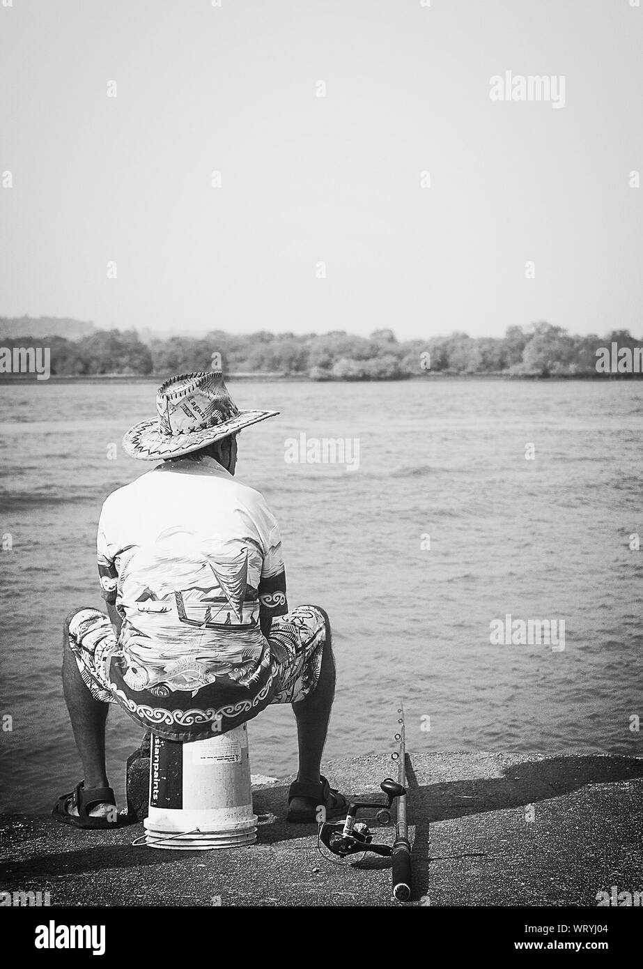 Man sitting on bucket Black and White Stock Photos & Images - Alamy