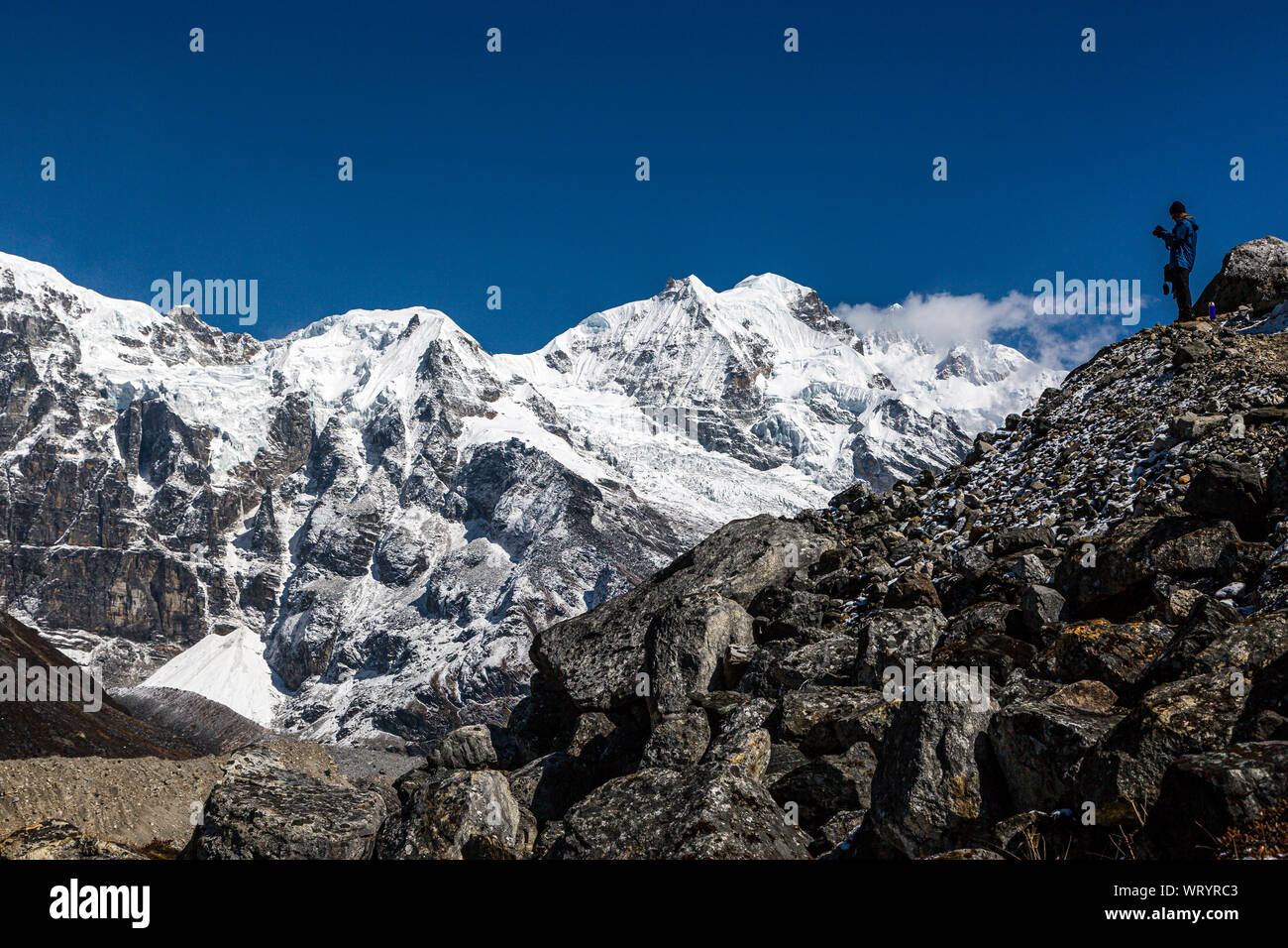 A trekker stands atop a mountain on the trekking route to Gochela pass ...