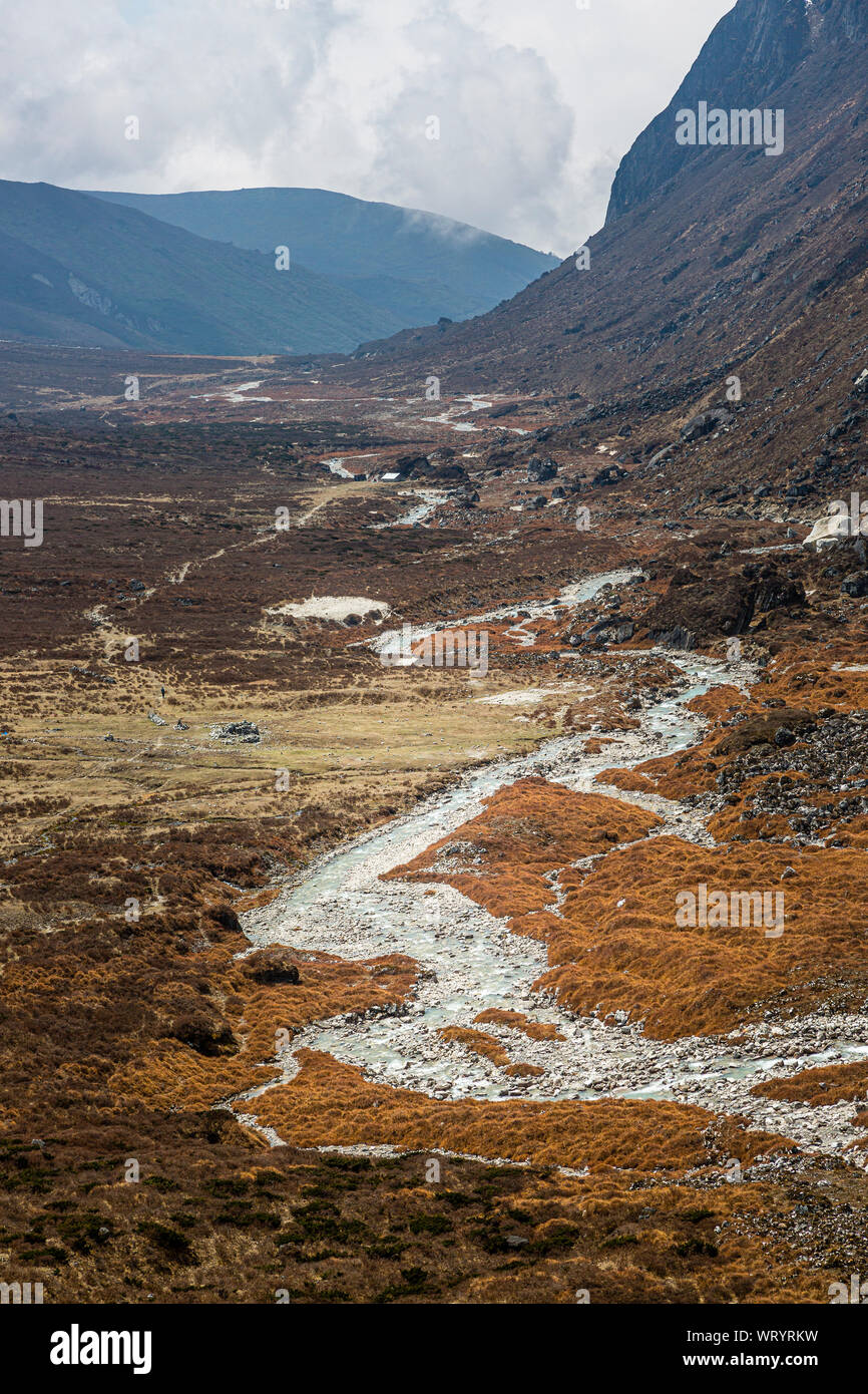 View of a valley and water stream on the trekking route to Gochela pass ...