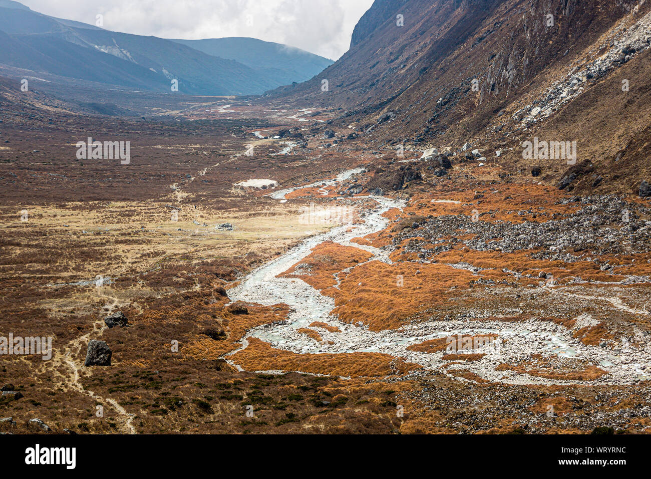 View of a valley and water stream on the trekking route to Gochela pass ...