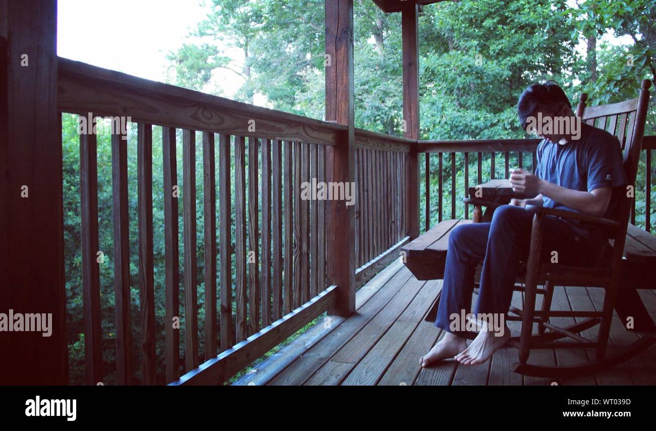 Man Sitting On Chair At Porch Stock Photo - Alamy