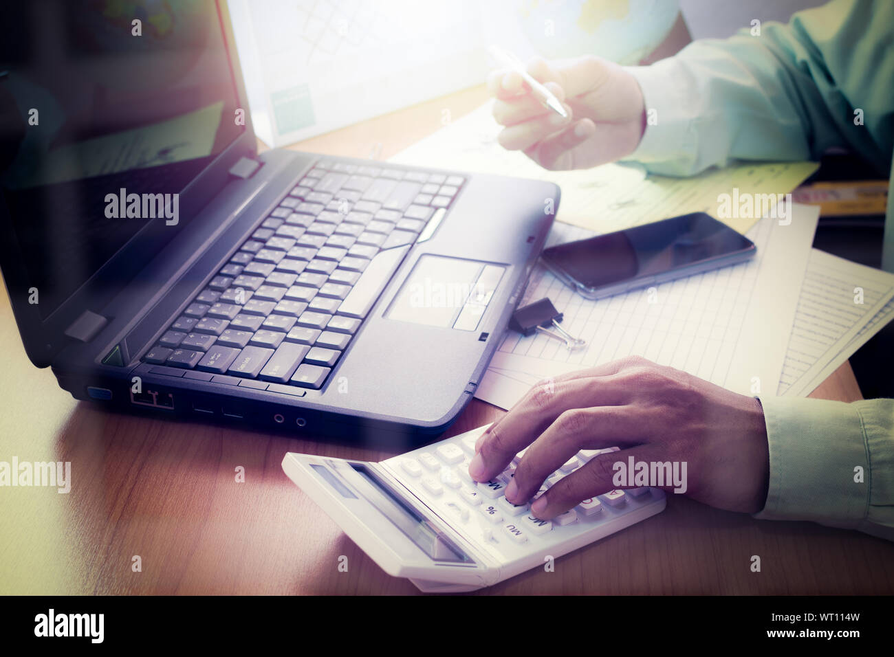 Hands of a business man working in office under shinning light. film ...