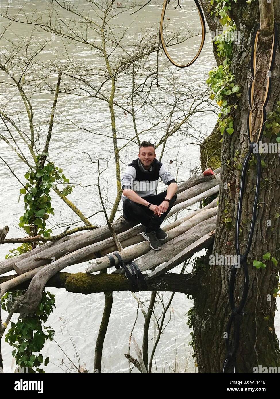Young man sitting on log hi-res stock photography and images - Alamy