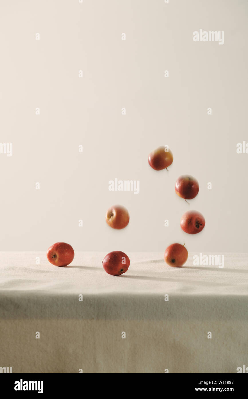 Falling red apples on table background Stock Photo - Alamy