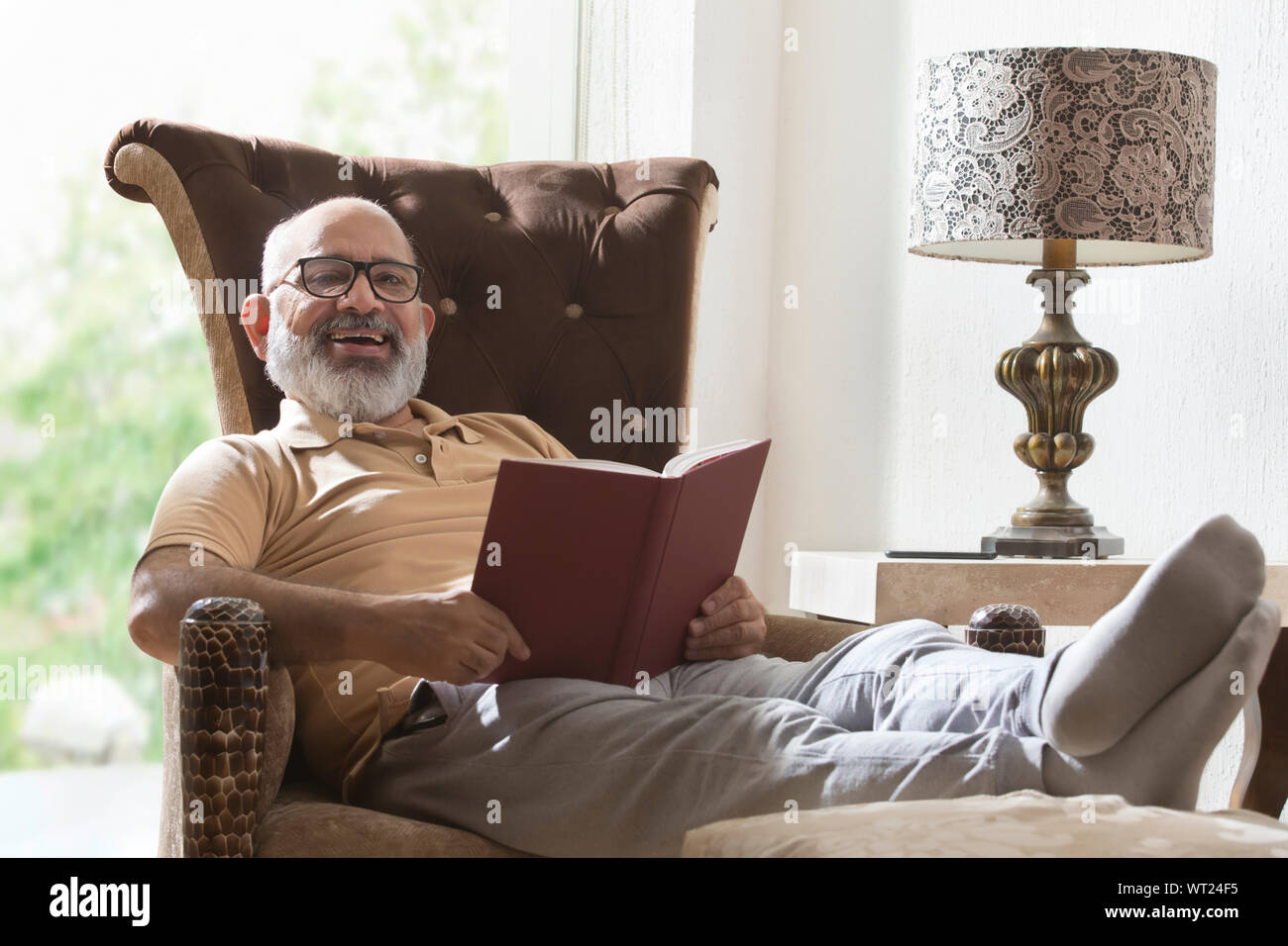 old man laughing while reading a book Stock Photo - Alamy