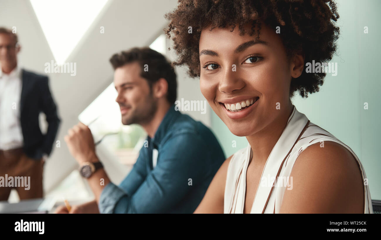 Feeling happy. Young afro american woman is looking at camera and ...