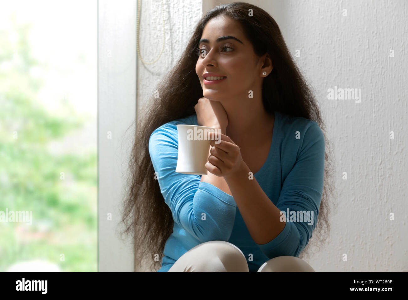 Woman looking outside living room hi-res stock photography and images ...