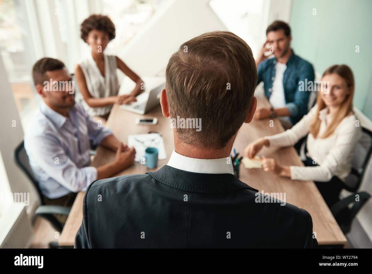 Back view of business man in formal wear discussing something with his ...