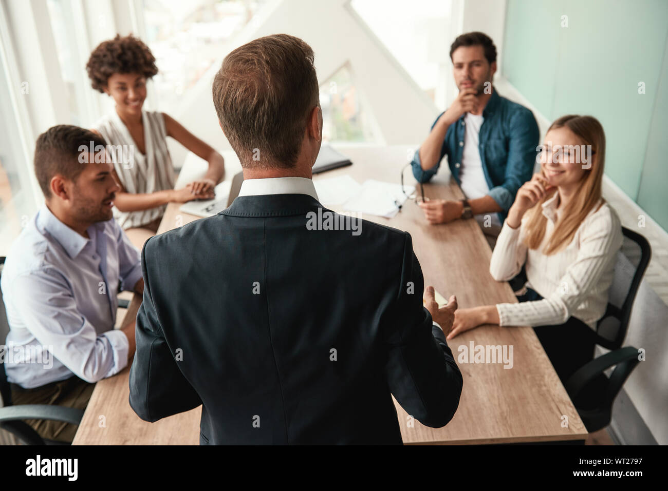 Business people. Back view of business man in formal wear discussing ...