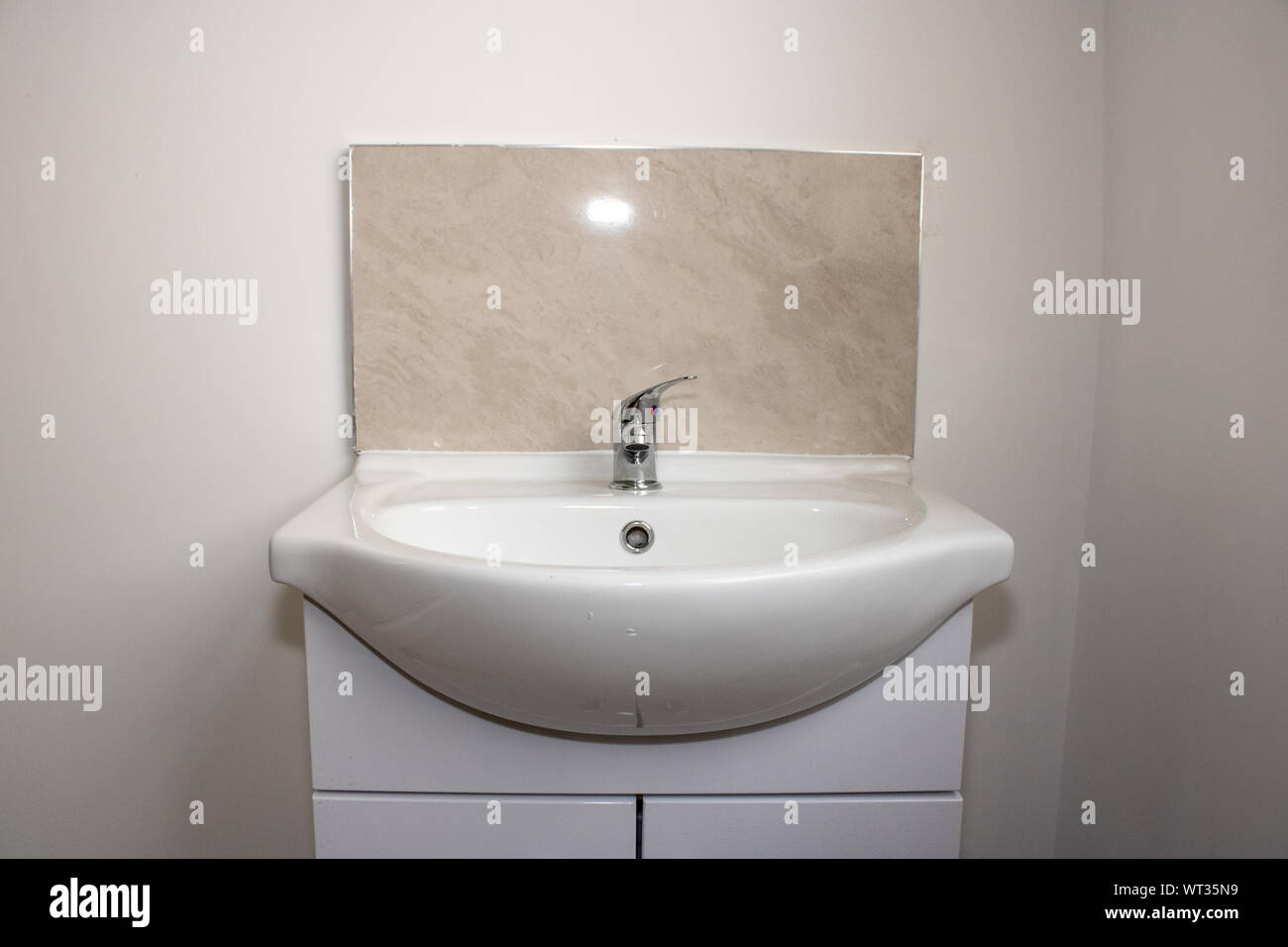 A typical UK British brand new bathroom sink with tile background Stock ...
