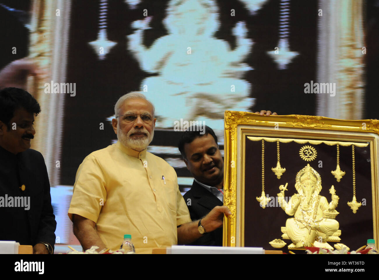Indian Prime Minister Narendra Modi holding a framed idol of the Hindu ...