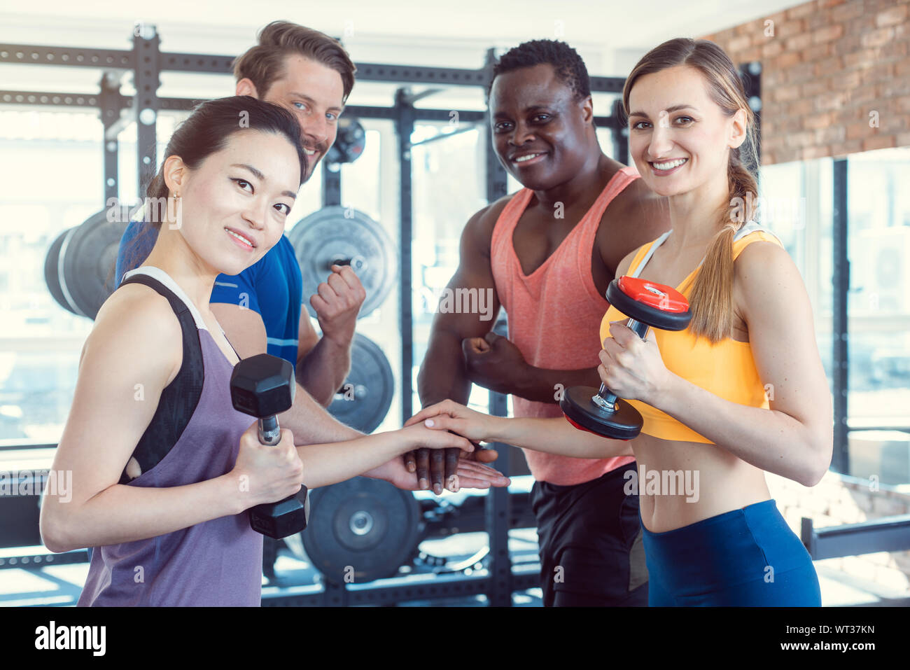 Four friends in the gym having fun Stock Photo - Alamy