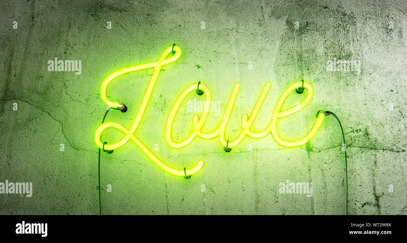 Neon sign that says the word Love in bright green colours, on a grunge ...