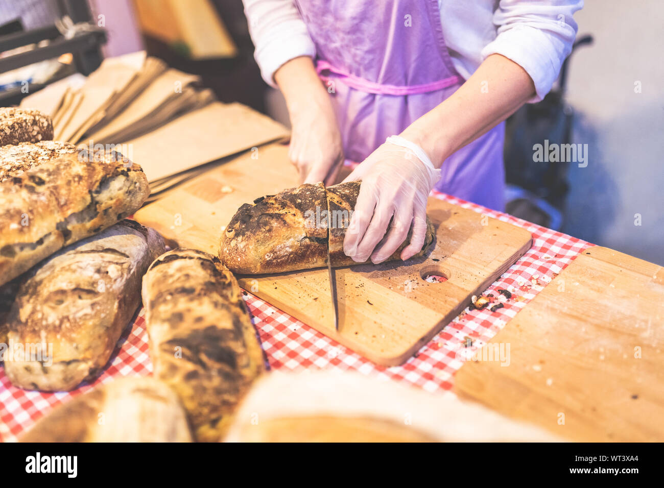 Close up of baker cutting whole grain bread Stock Photo - Alamy