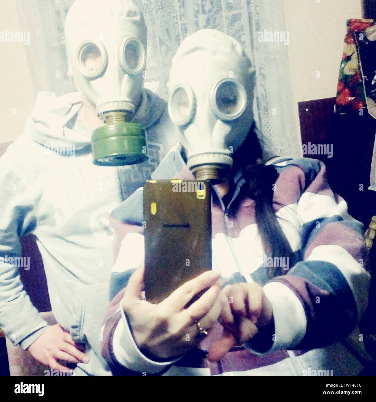 Friends Wearing Gas Mask Taking Selfie At Home Stock Photo - Alamy