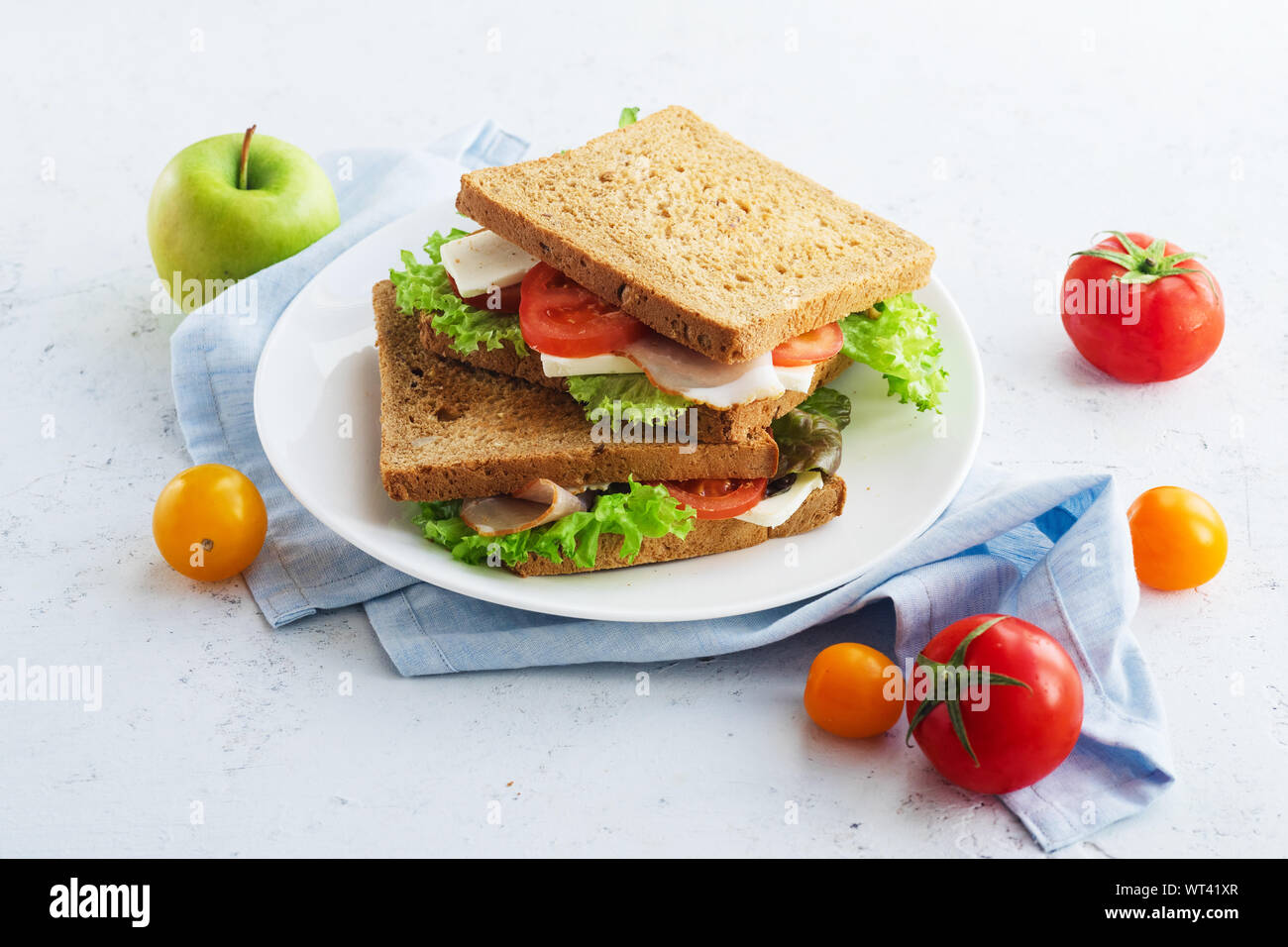 Overhead shot of a healthy sandwich with greens, ham, tomatoes and ...
