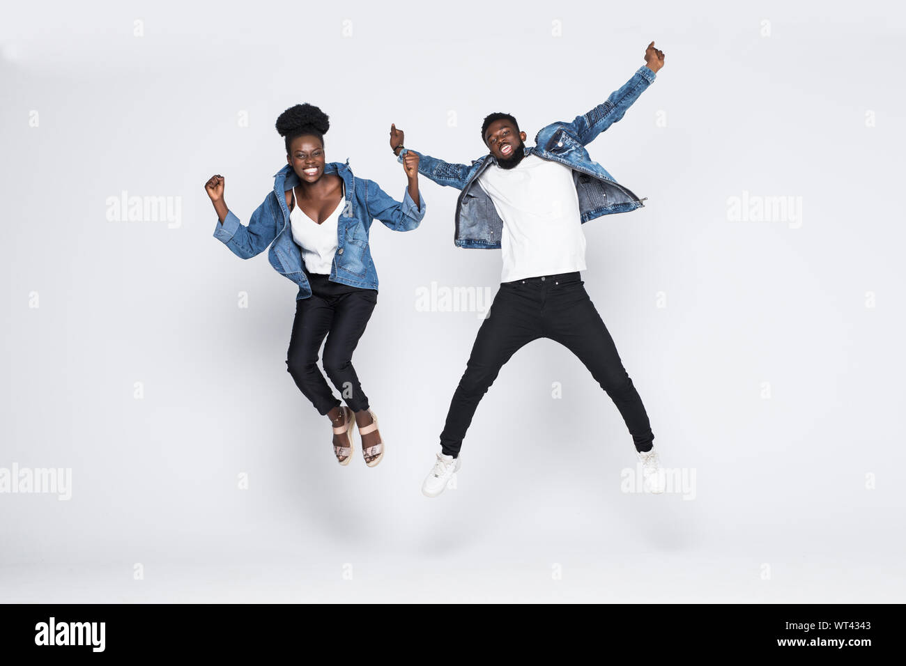 Portrait of a surprised young afro american couple jumping together ...