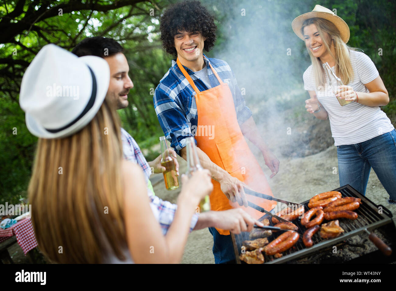 Happy friends enjoying barbecue and grill party outdoor Stock Photo - Alamy
