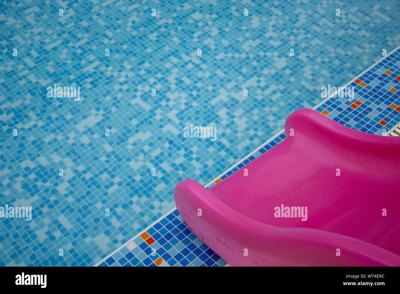 Close up of a hotel Swimming pool with pink children's slide at the ...