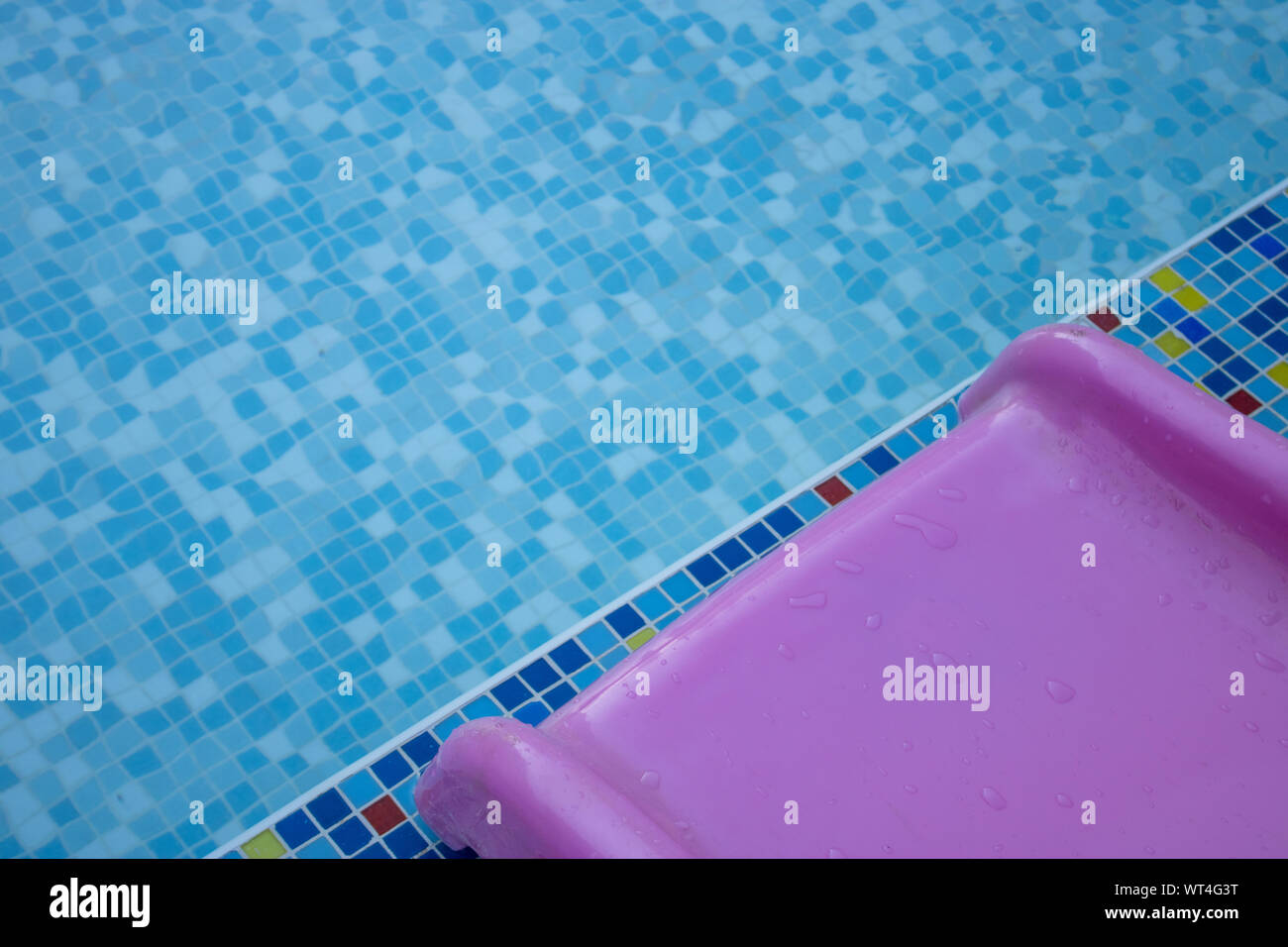 Close up of a hotel Swimming pool with purple children's slide at the ...