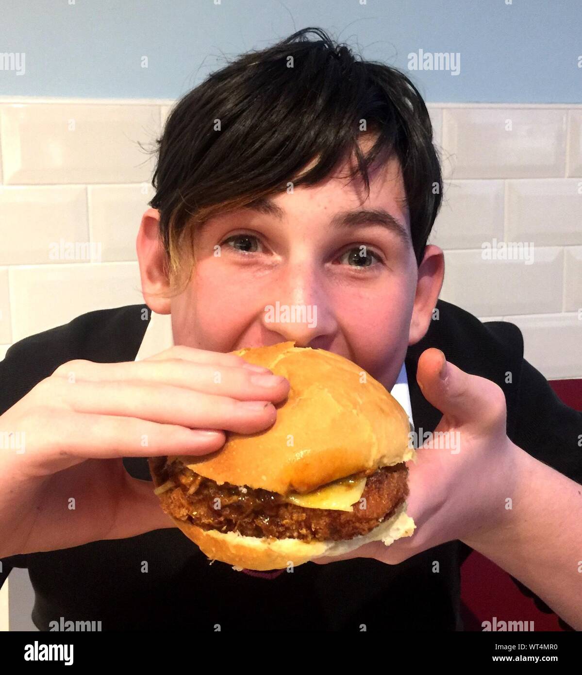 Young eating hamburger hi-res stock photography and images - Alamy