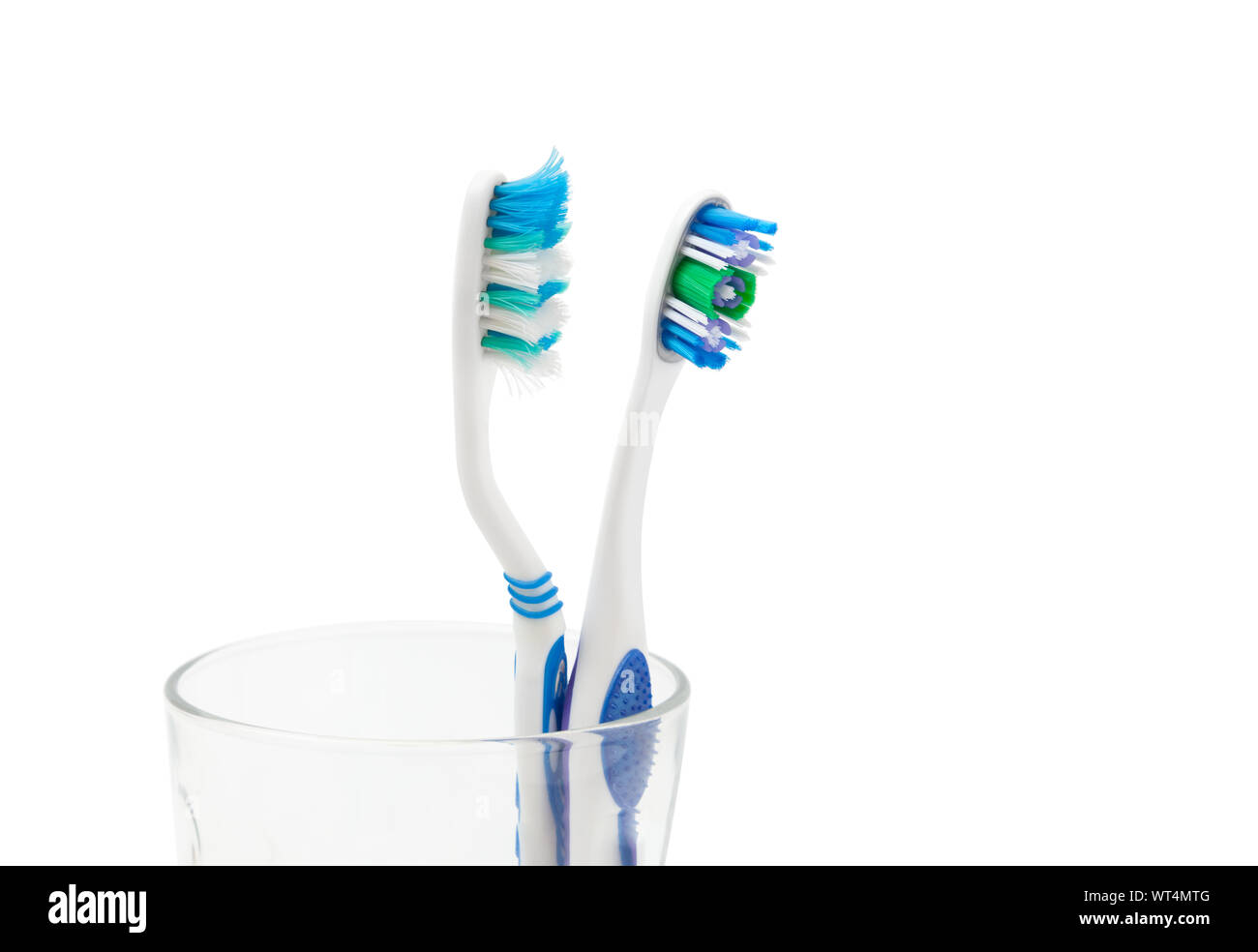 New toothbrush and old toothbrush (damaged) in clear glass for teeth ...