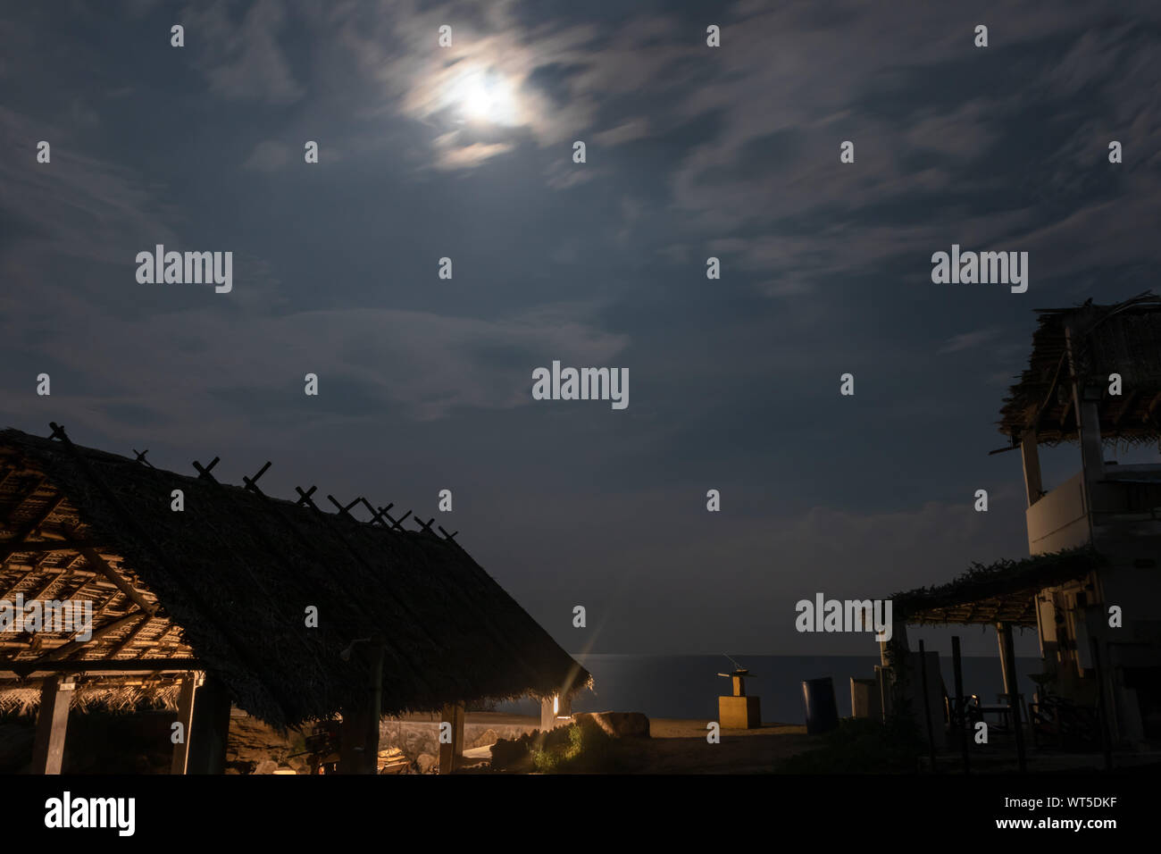 Rustic village home in a moon light near sea shore image is showing the ...