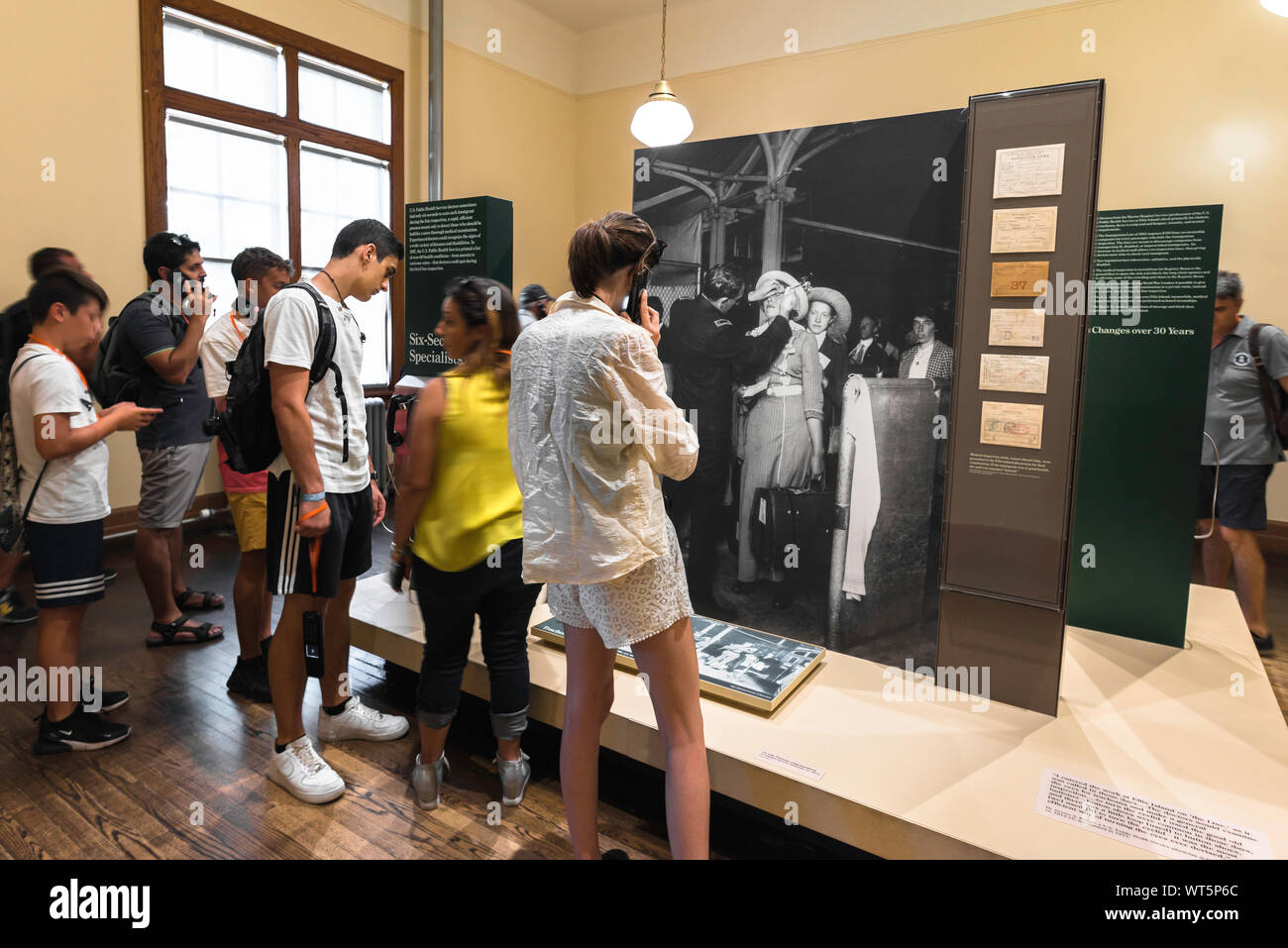 Immigration USA, visitors to Ellis Island Museum view a display ...