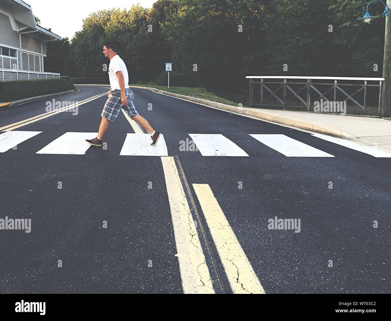Young man crossing road hi-res stock photography and images - Alamy