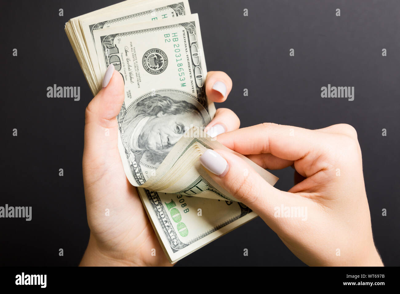 Top view of female hands counting money. One hundred dollar banknotes ...