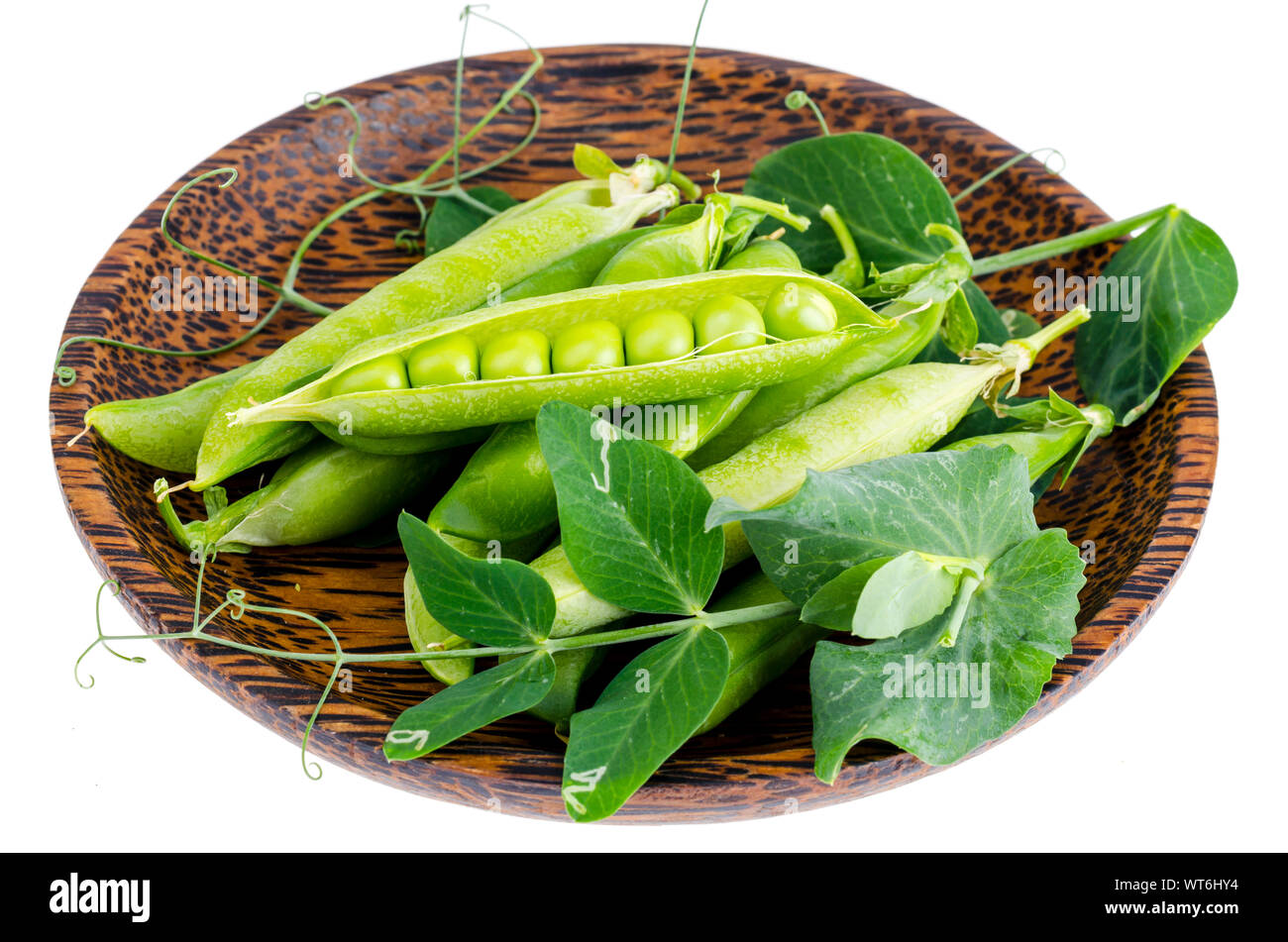 Wooden plate with green pea pods. Studio Photo Stock Photo - Alamy