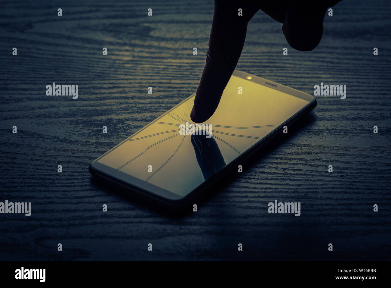 close up of a human finger touching a cracked phone screen - Cyber ...
