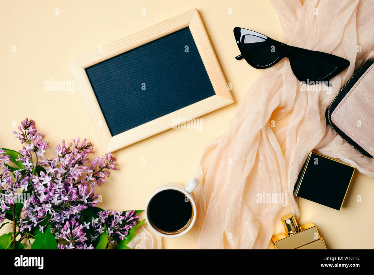 Female workspace with photo frame, sunglasses, silk scarf, coffee cup ...