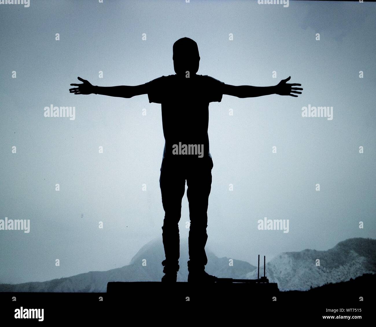 Silhouette man standing arms outstretched hi-res stock photography and ...