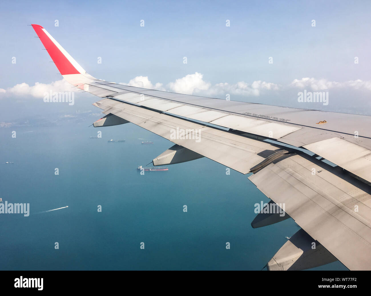 View of the aircraft wing which above the cargo ship before landing to ...
