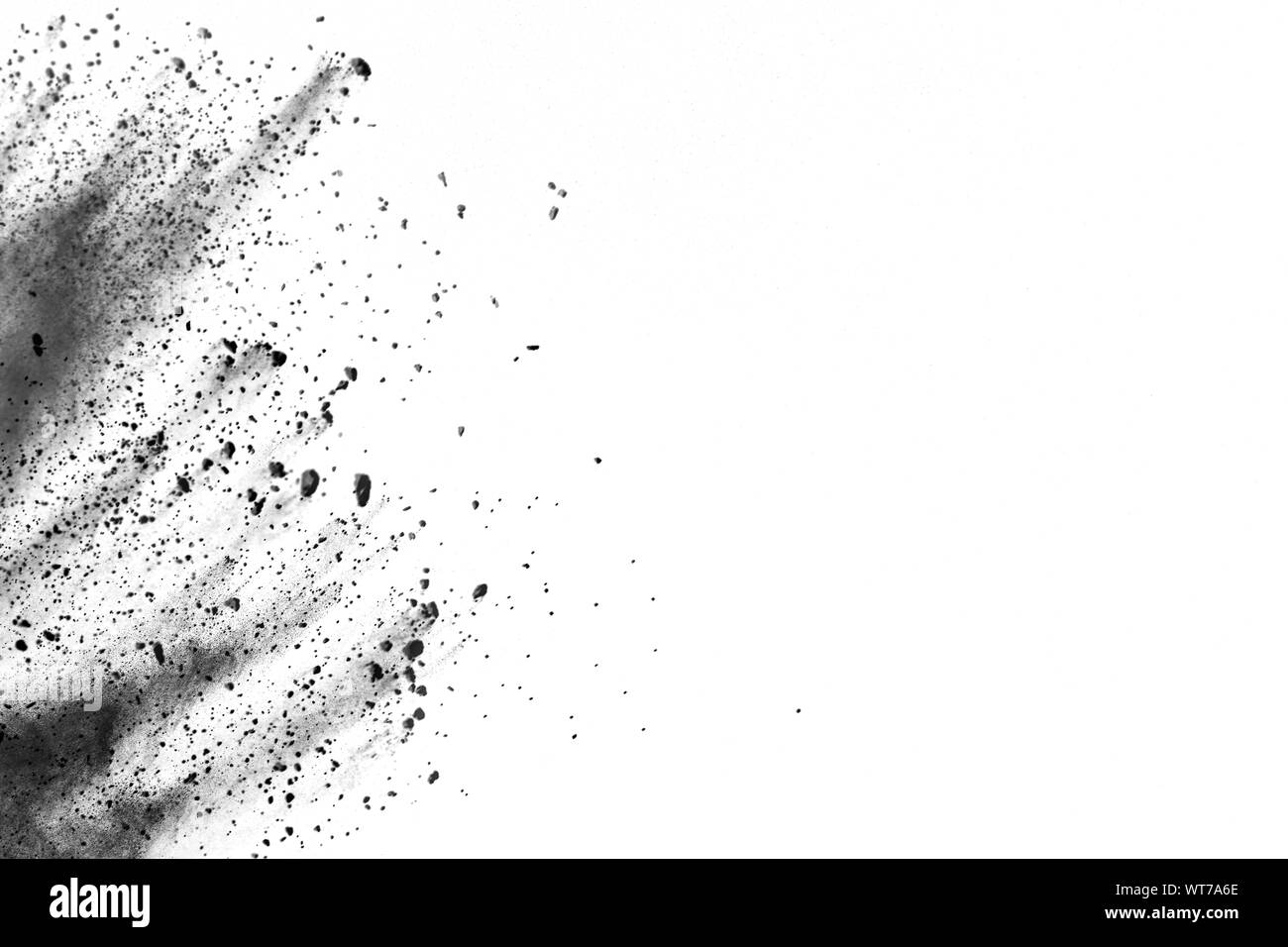 Black powder explosion. The particles of charcoal splatter on white ...