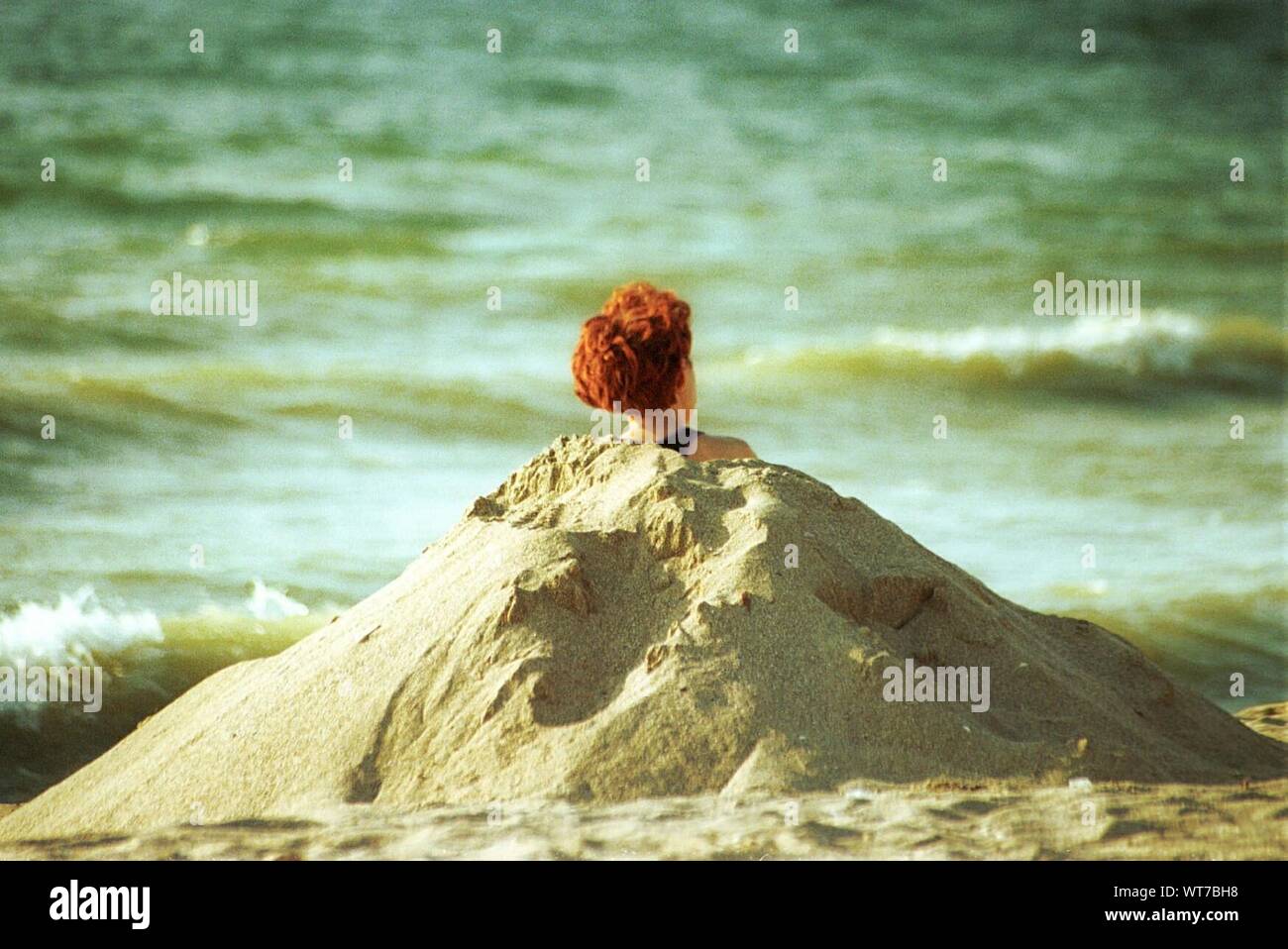 Optical Illusion Of Person Covered With Sand Against Sea Stock Photo ...