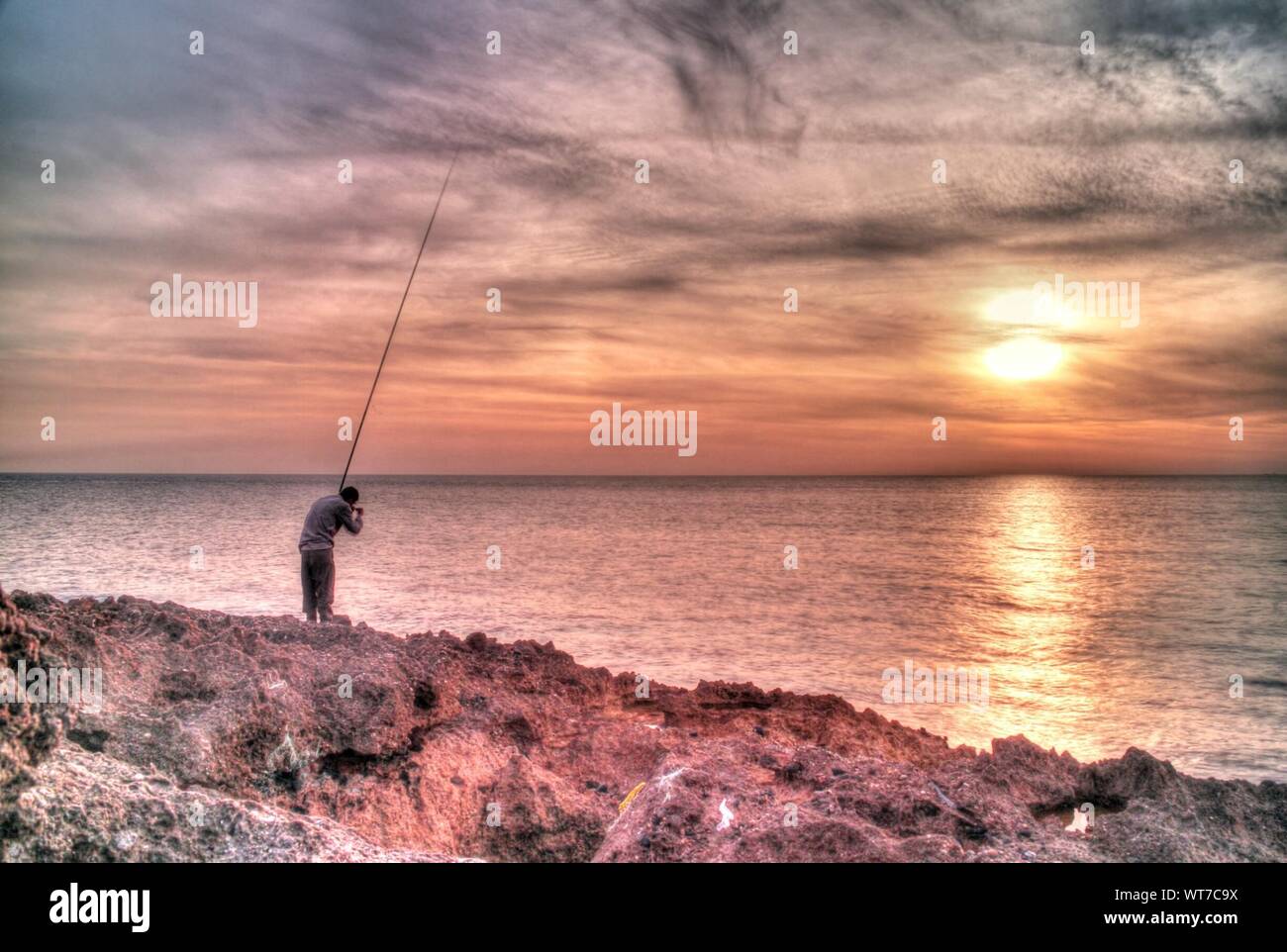 Man fishing in sea dusk activity hi-res stock photography and images ...