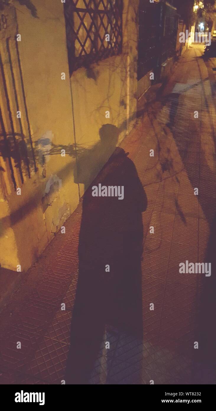 Shadow Of Man On Sidewalk At Night Stock Photo - Alamy