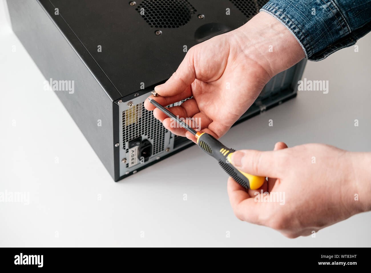 Technician disassemble computer with a screwdriver for problems ...
