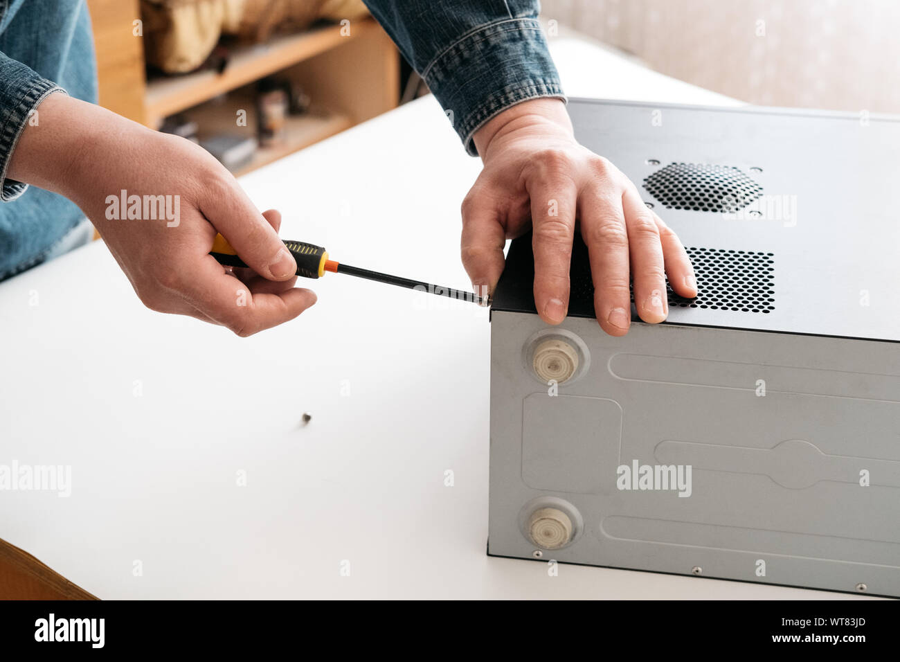 Technician disassemble computer with a screwdriver for problems ...