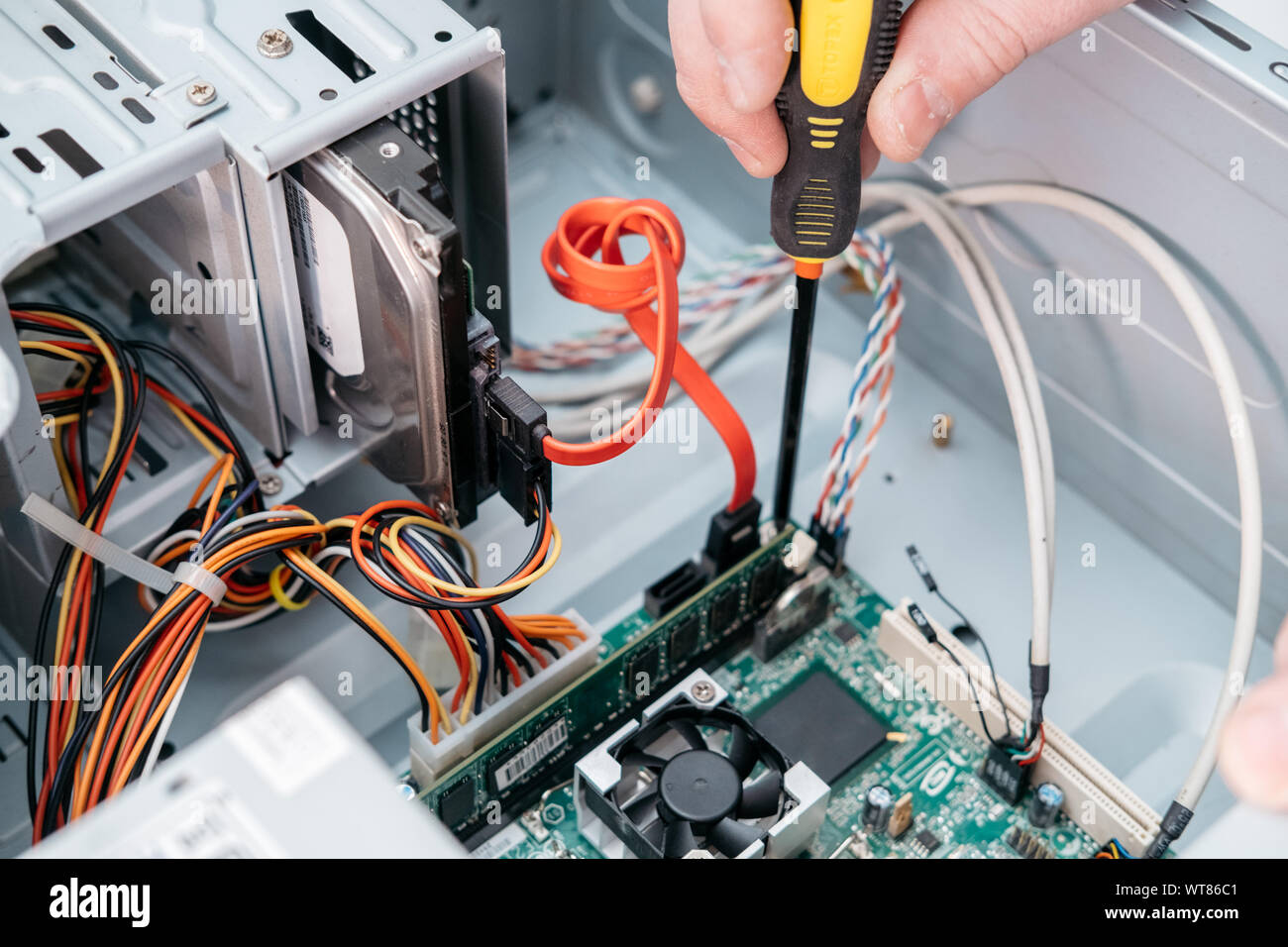 Hand of computer engineer with screwdriver is mount computer ...