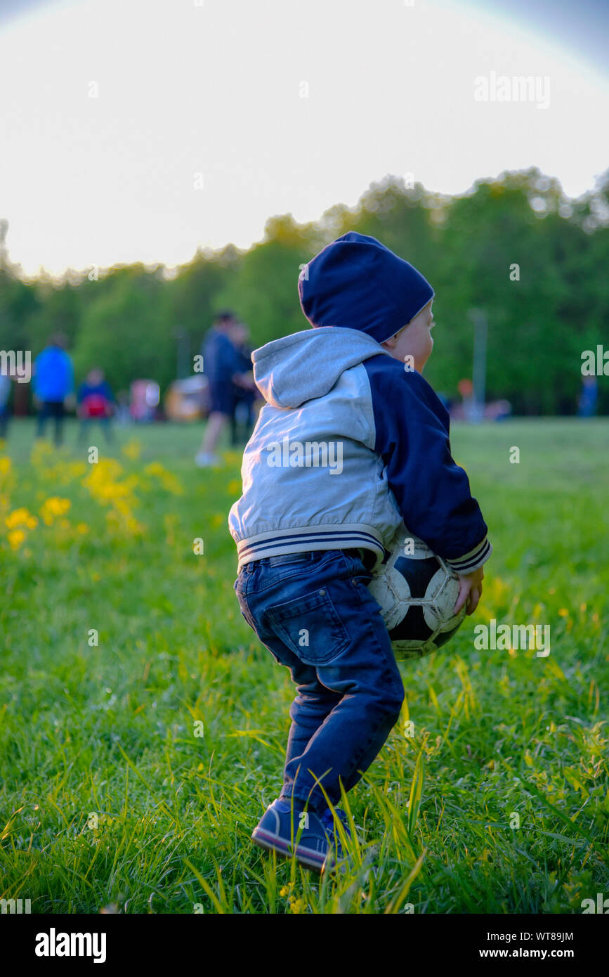 Child chasing ball hi-res stock photography and images - Alamy