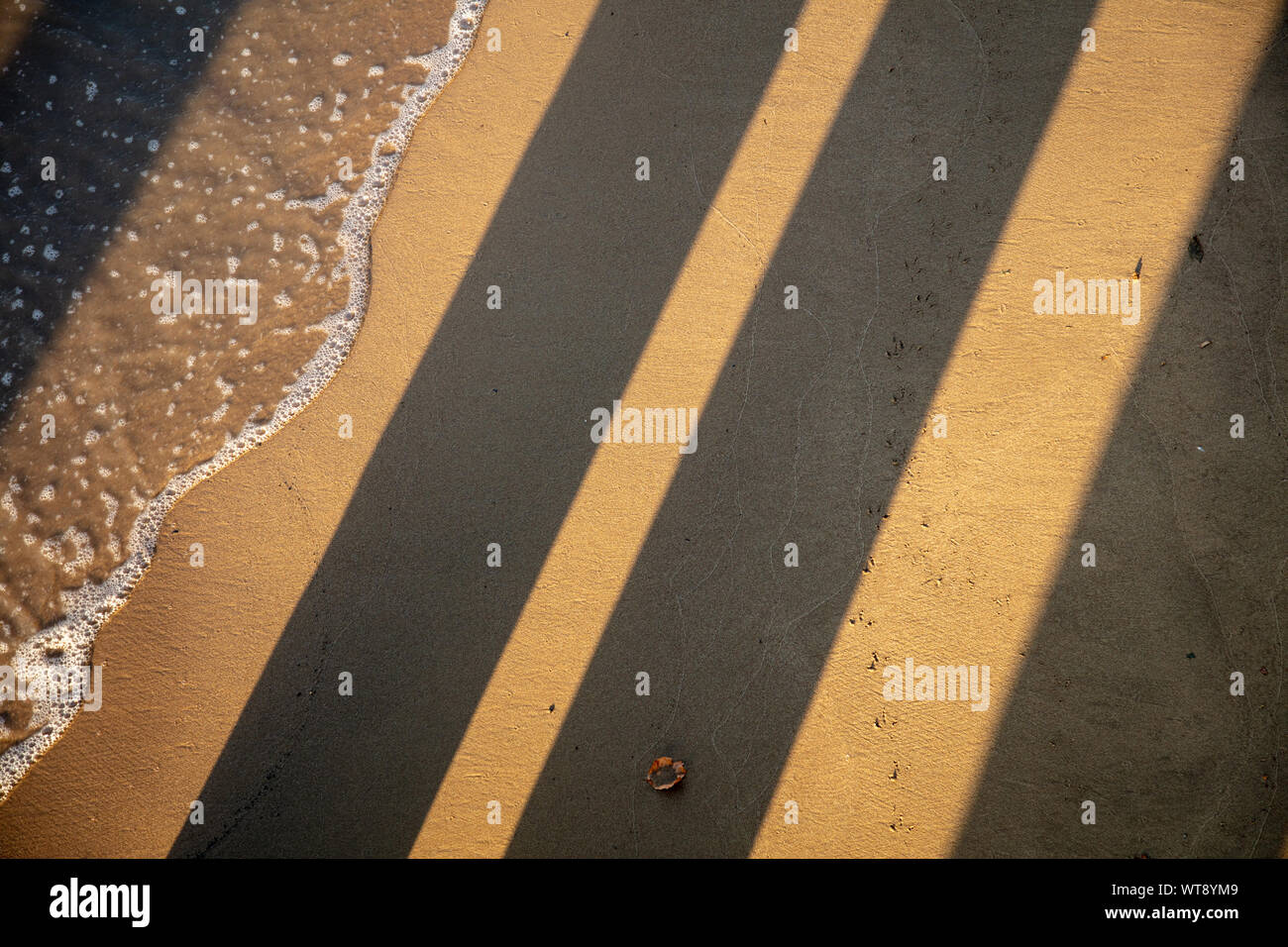 Strong lines of light and shadow on the sandy beach of the London river ...