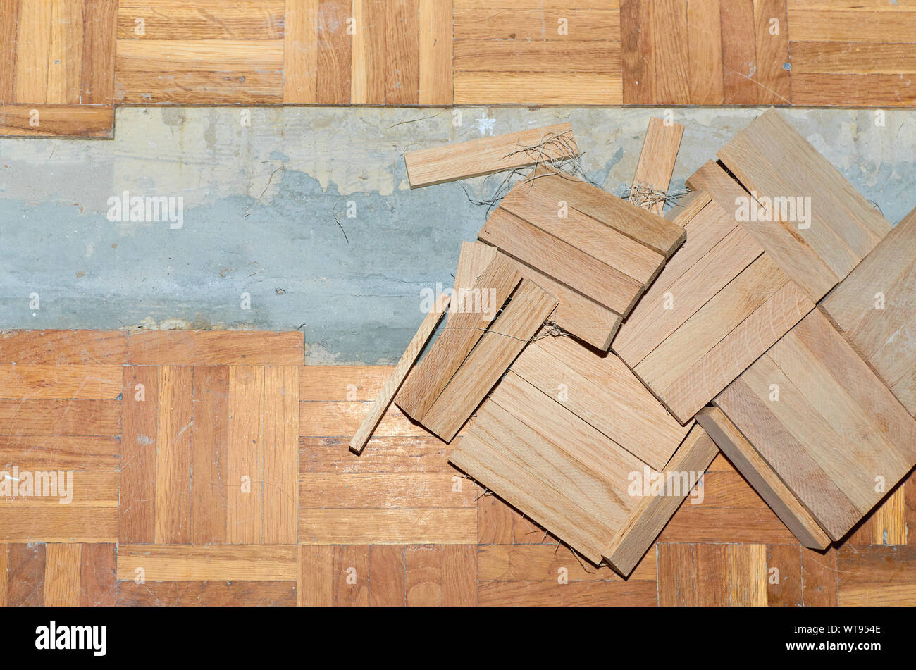 Renovation of a damaged parquet while fixing new wooden tiles instead ...