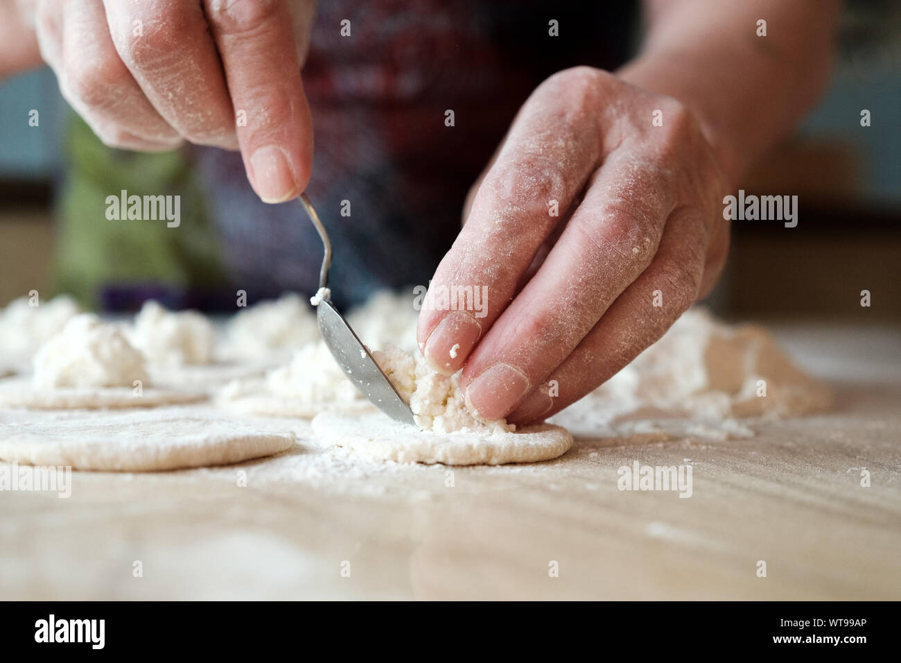 Rolled dough with cottage cheese on wooden table. Process of making ...
