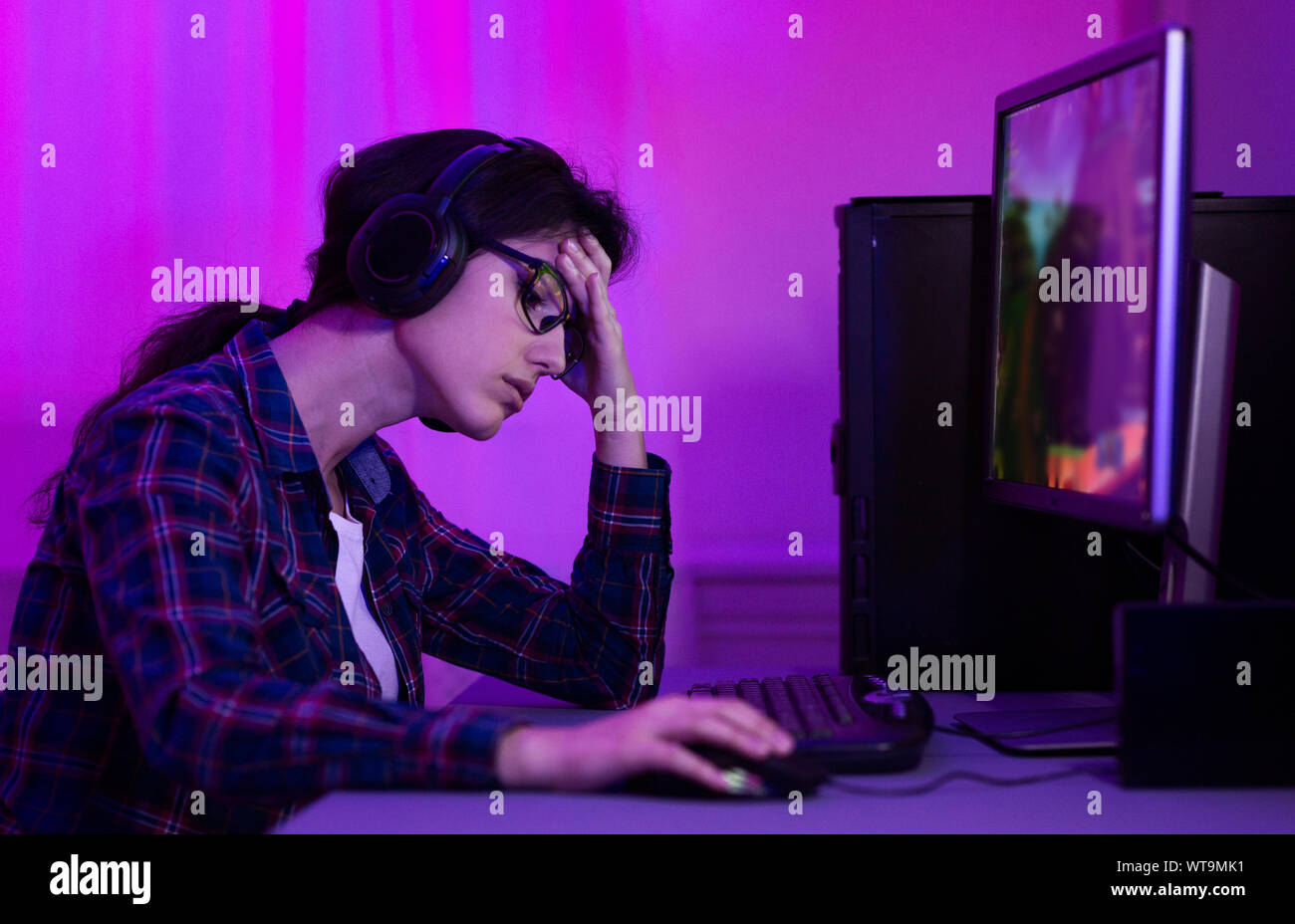 Bored female gamer playing video games on computer Stock Photo - Alamy